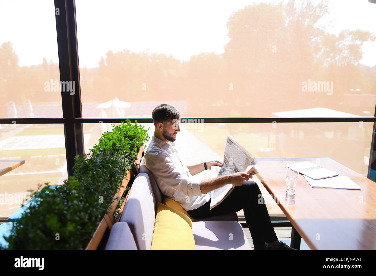 Handsome male person reading newspaper and wondering Stock Photo - Alamy