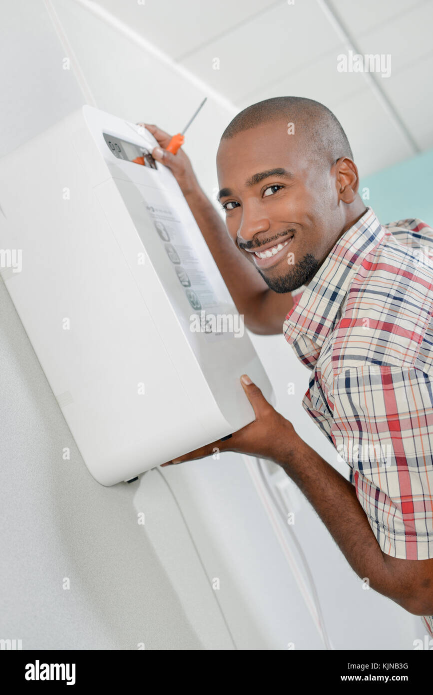 Man fitting box to wall Stock Photo - Alamy