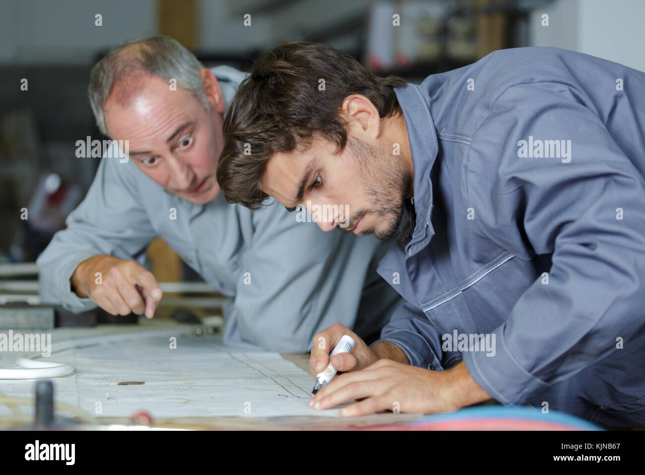 workman making alterations to drawings Stock Photo - Alamy