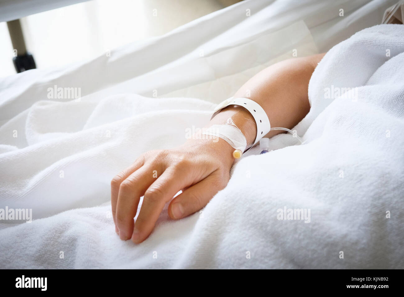 Closeup of intravenous tube on patient's hand in hospital bed, AF point ...