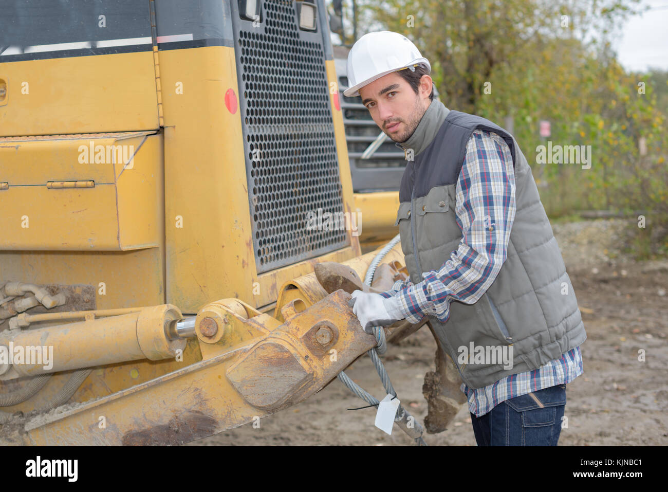 man posing next to a heavy equipment Stock Photo - Alamy