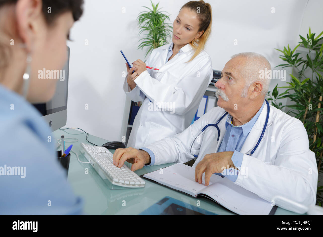 doctor using computer while in consultation with female patient Stock ...