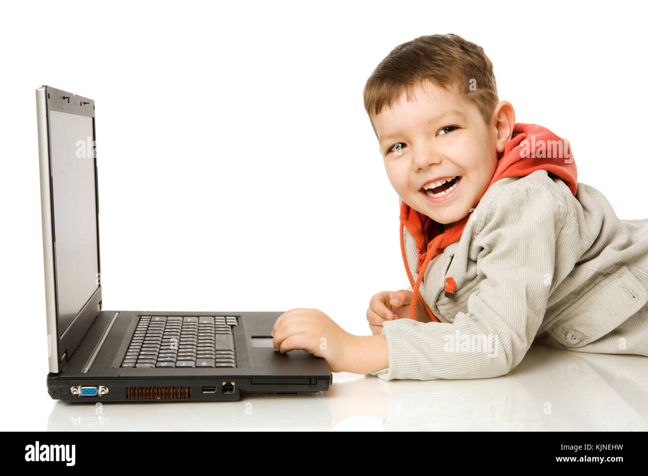 Boy typing on laptop and laughing isolated on white Stock Photo - Alamy