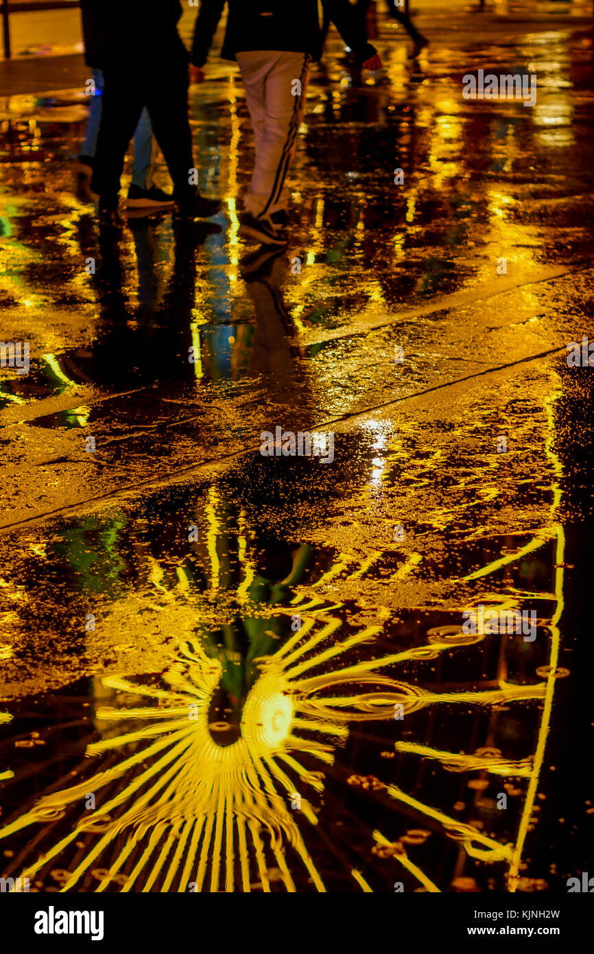 Traditional Ferris Wheel reflects on wet pavement, Lyon, France Stock ...
