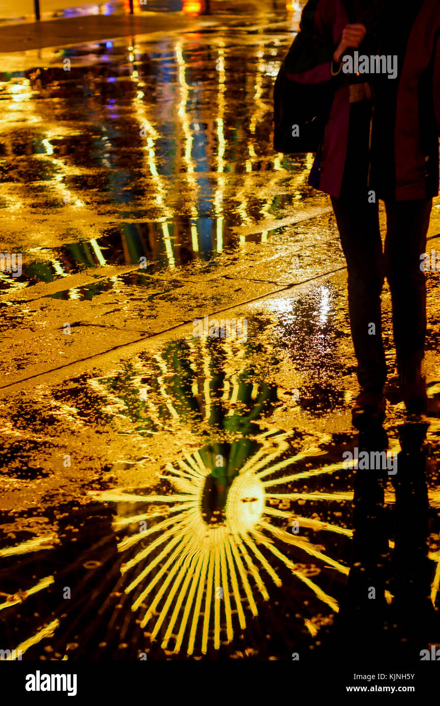 Traditional Ferris Wheel reflects on wet pavement, Lyon, France Stock ...