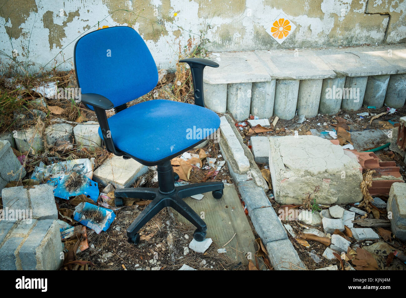 Blue office chair in a ruin full of rubble and waste, a crisis concept ...