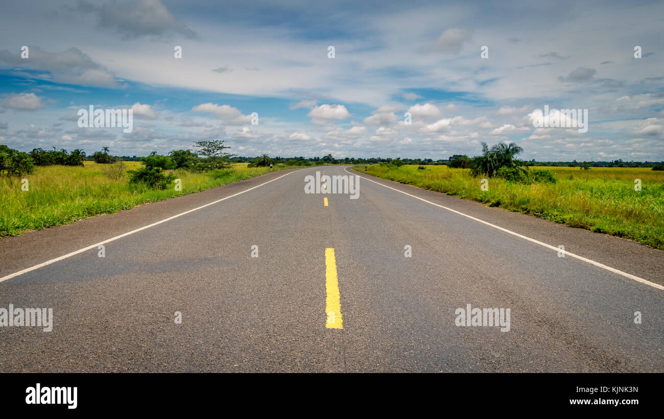 Endless highway through the Uganda landscape with a few bikers with ...