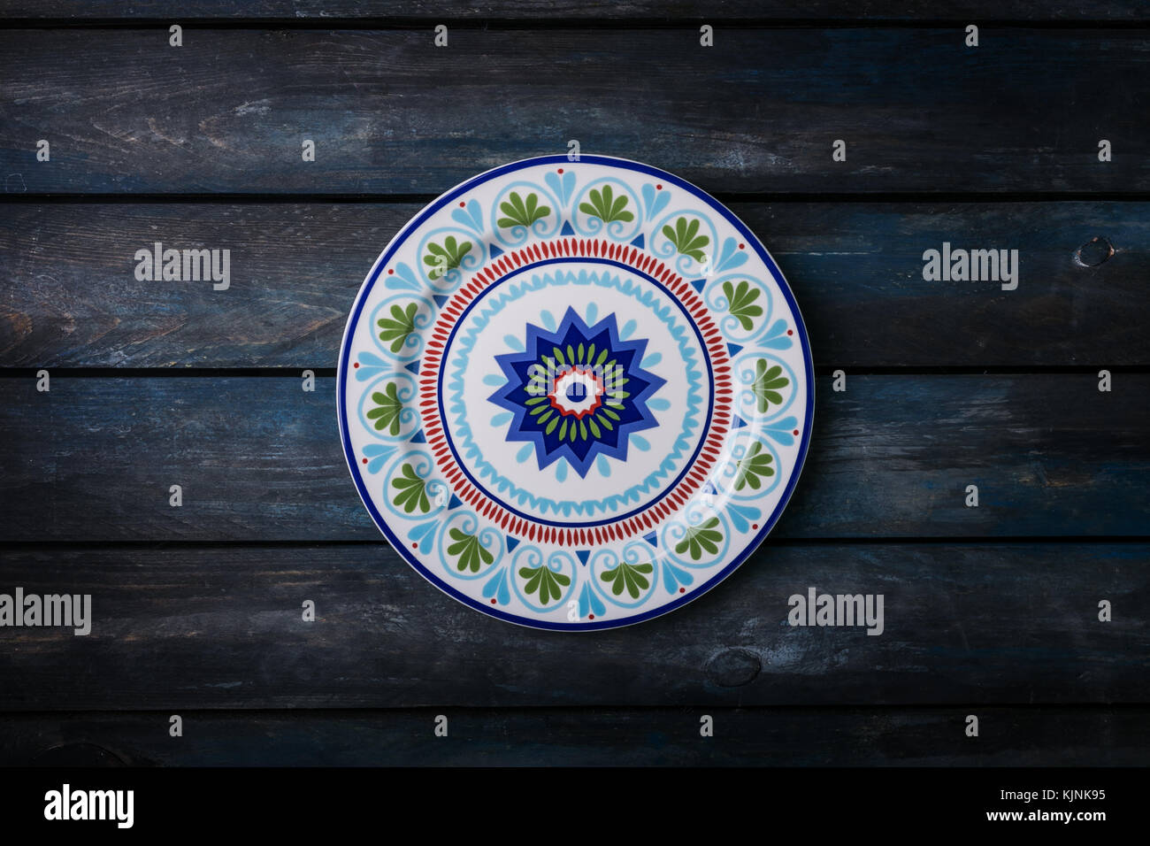 Original ceramic plate with beautiful colorful ornament. Top view dark ...