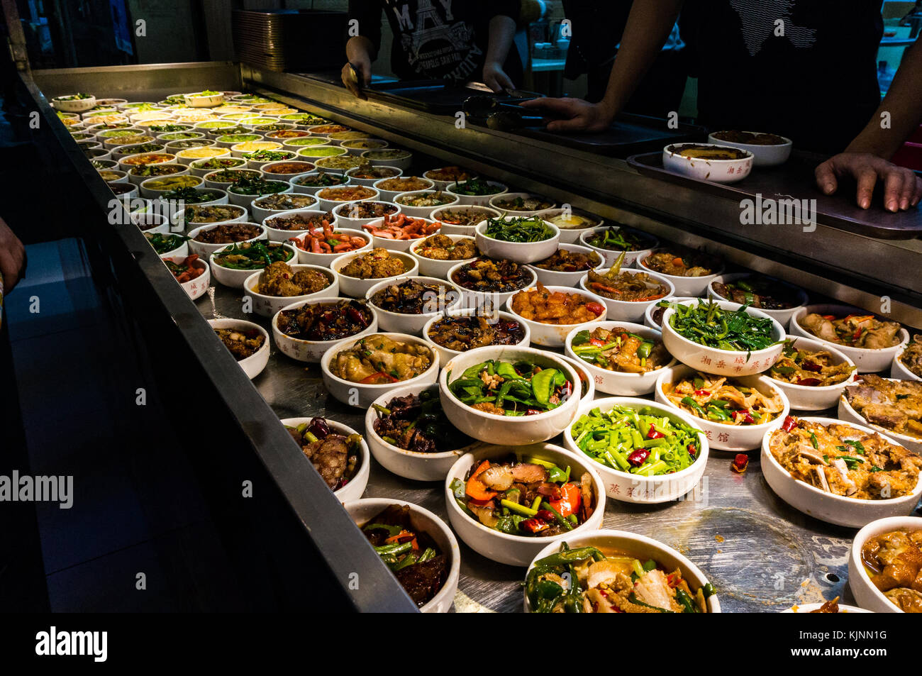 Chinese food in bowls arranged in rows at street food stand in Pingzhou ...