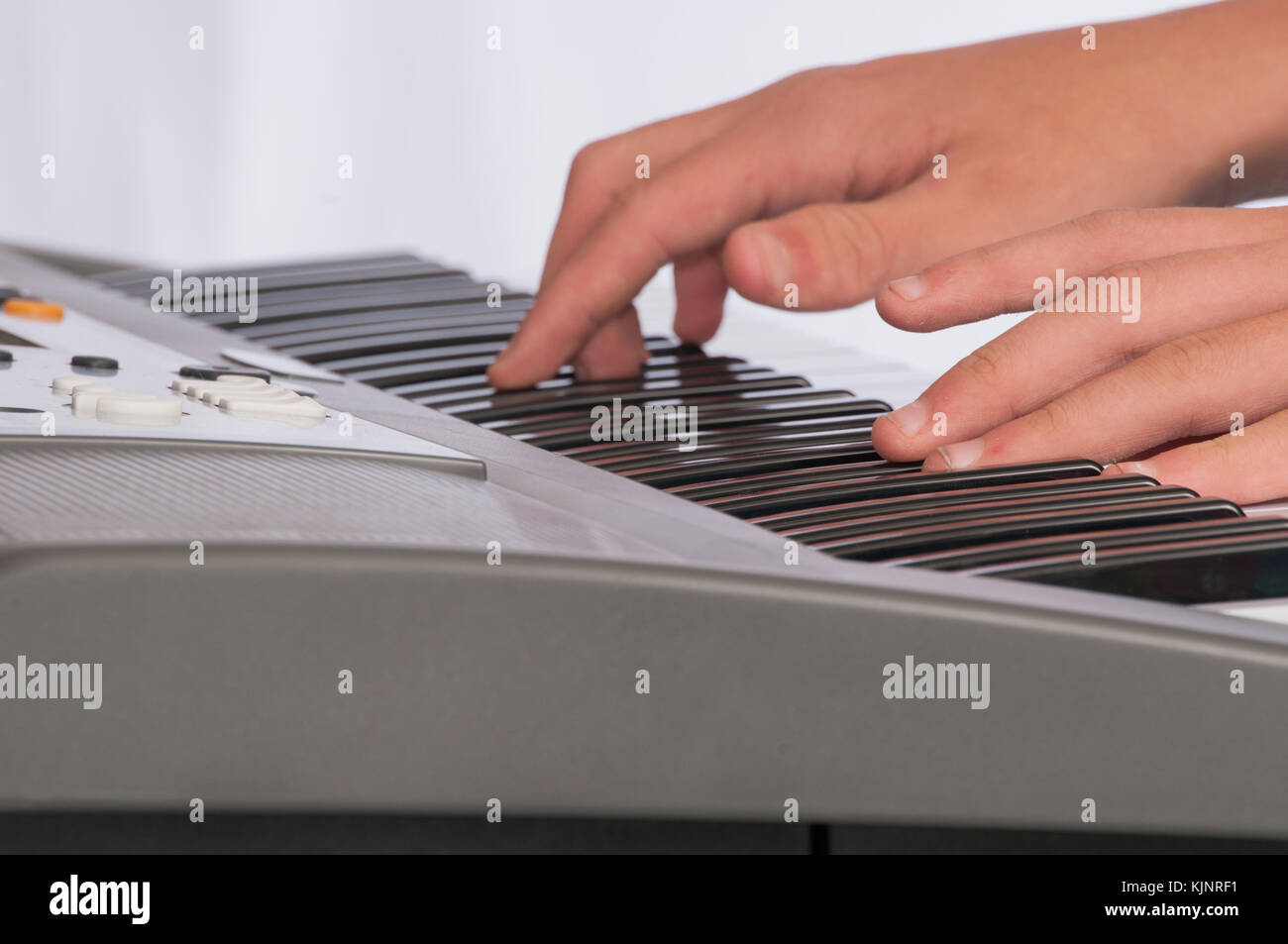 Two hands playing an electronic keyboard Stock Photo - Alamy