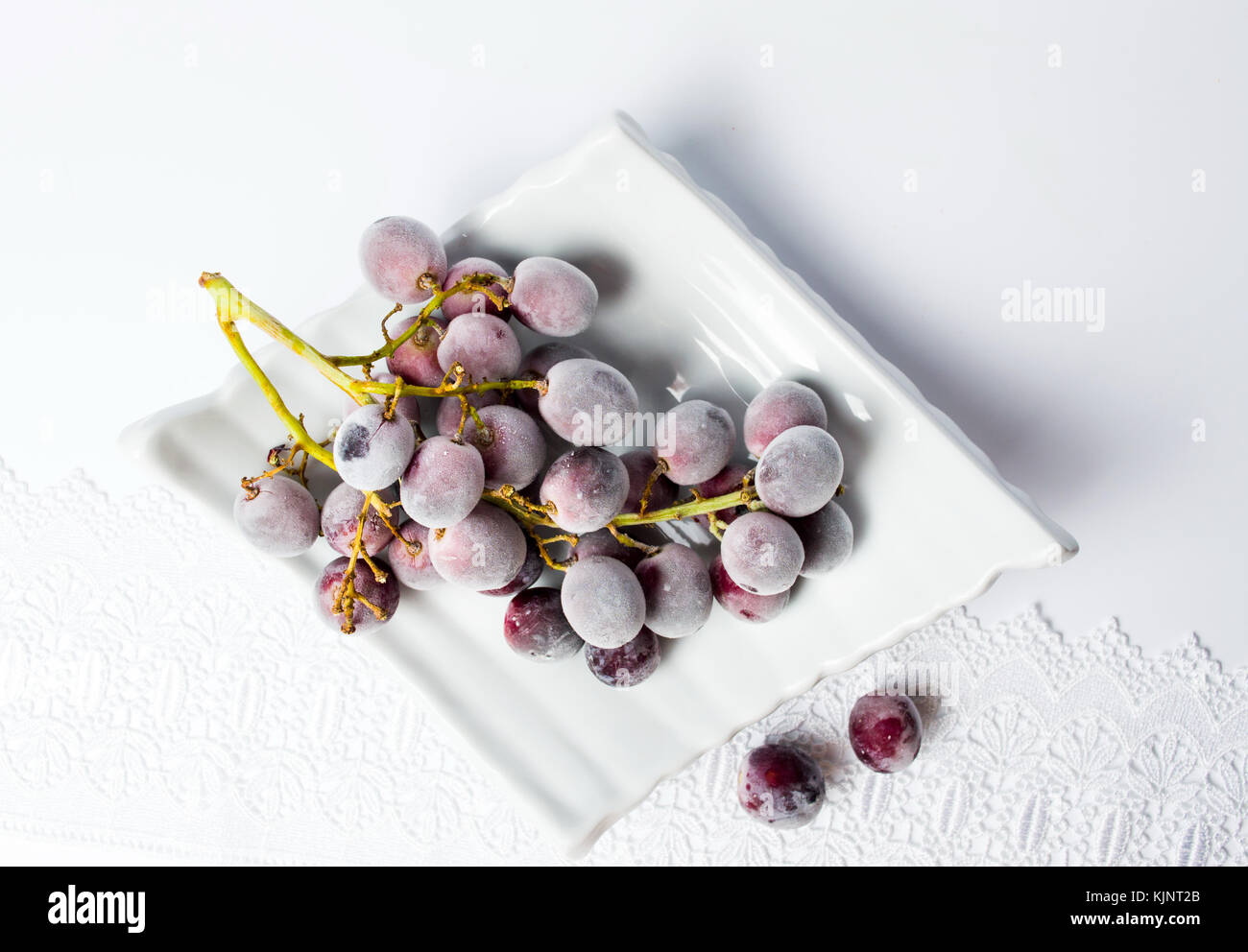 Frozen grapes cluster with ice on white background Stock Photo - Alamy