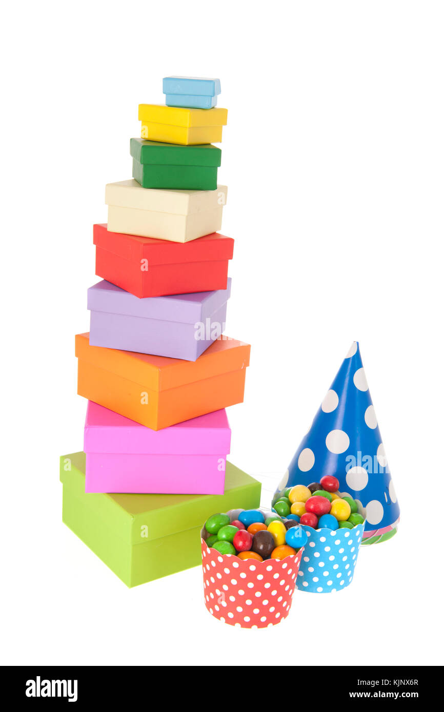 Stack birthday gifts and candy with party hats Stock Photo - Alamy
