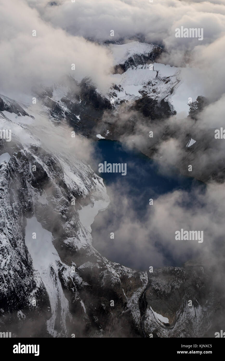 Aerial abstract landscape of the rugged mountains covered in clouds ...