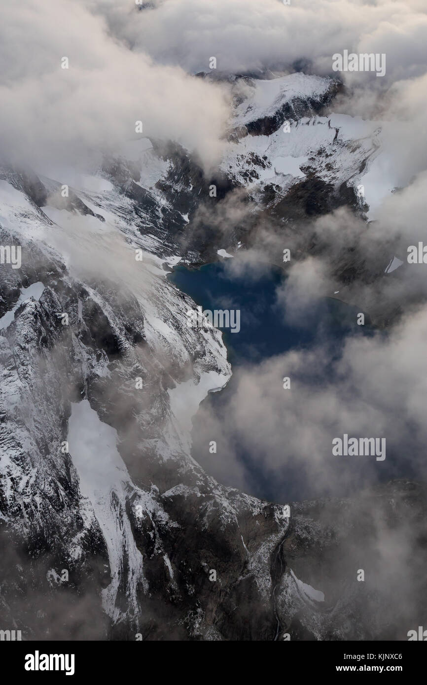 Aerial abstract landscape of the rugged mountains covered in clouds ...