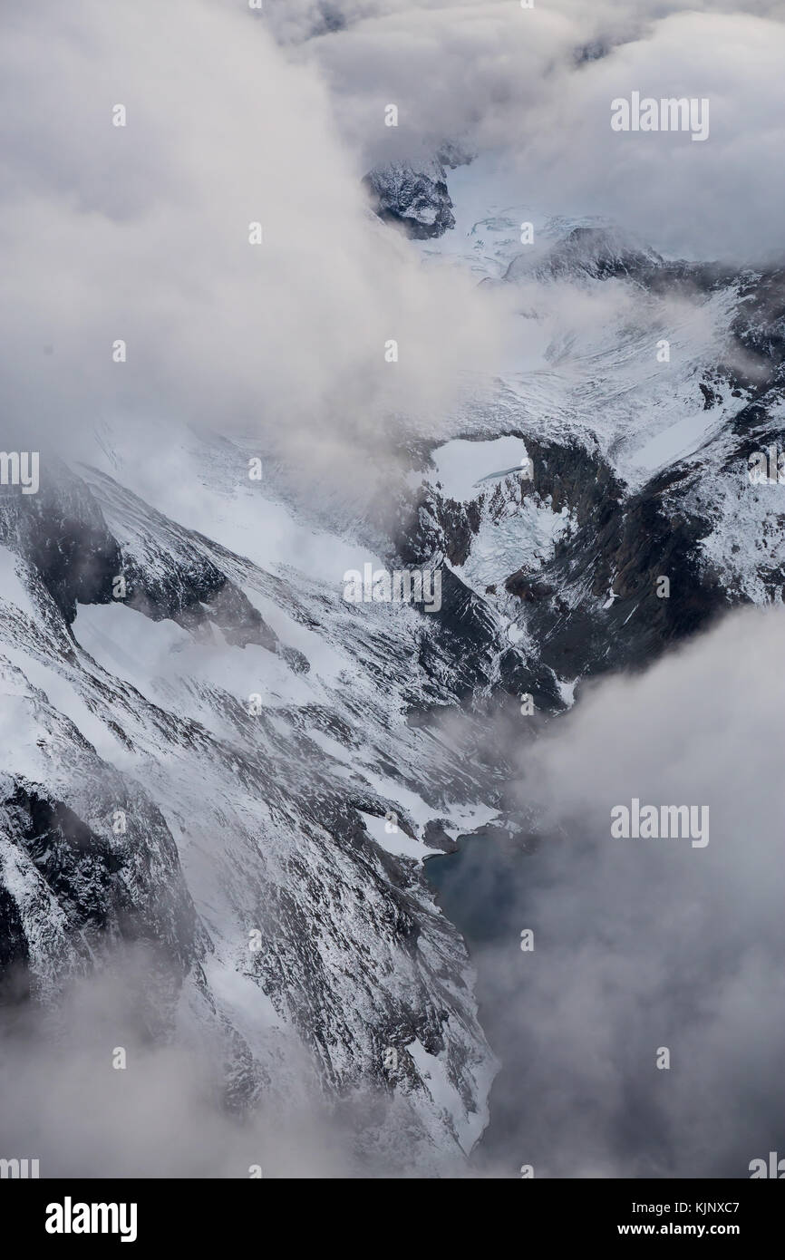 Aerial abstract landscape of the rugged mountains covered in clouds ...