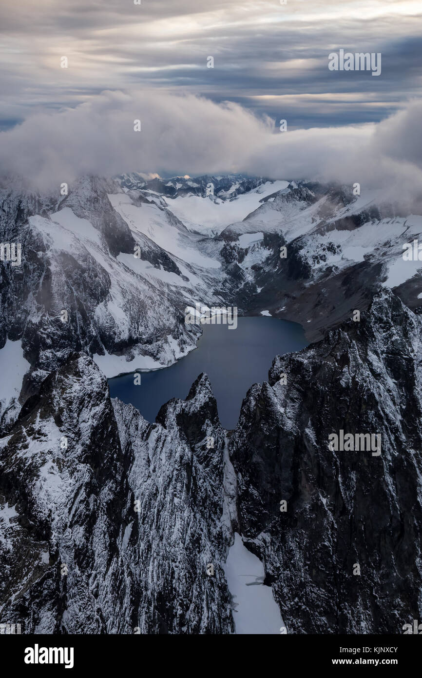Aerial abstract landscape of the rugged mountains covered in clouds ...