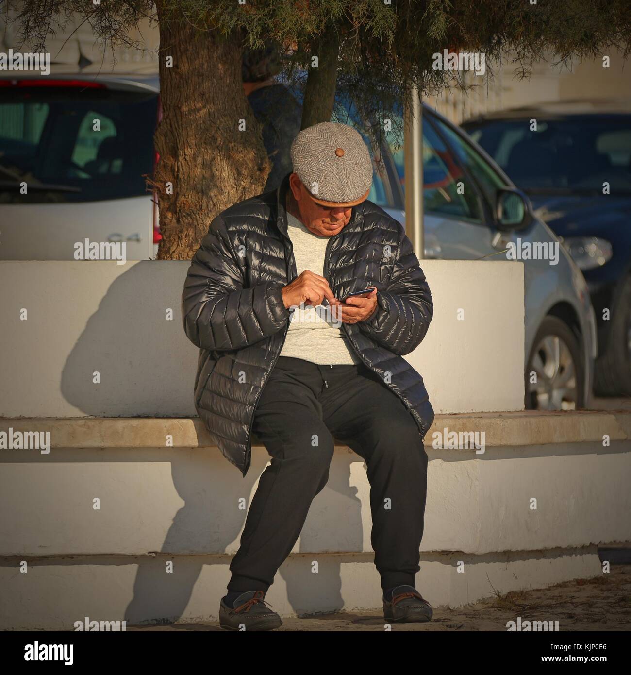 senior using his mobile phone in a public place Stock Photo - Alamy