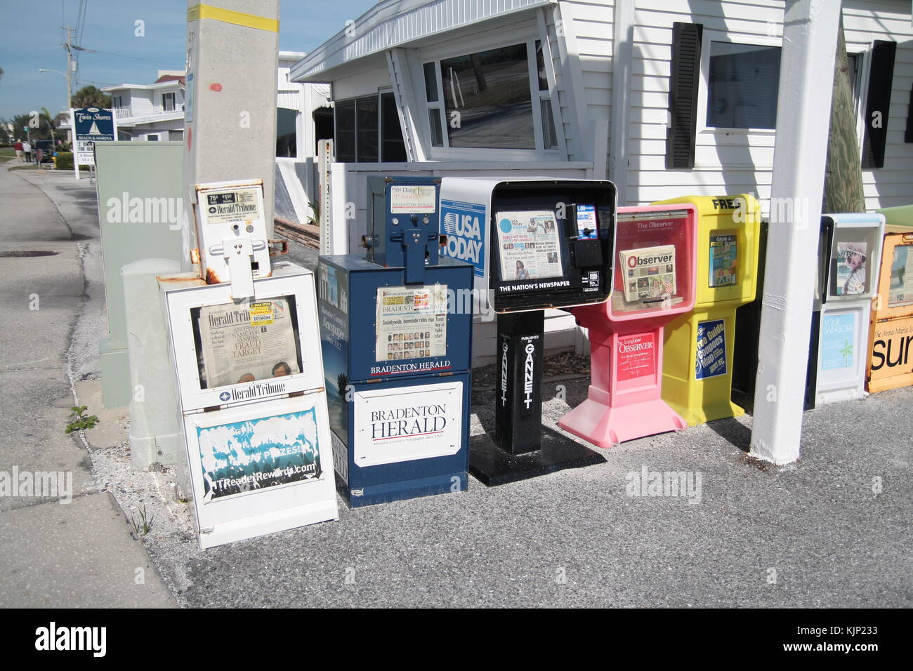 Newspaper vending machines boxes aligned on the sidewalk on a sunny day ...