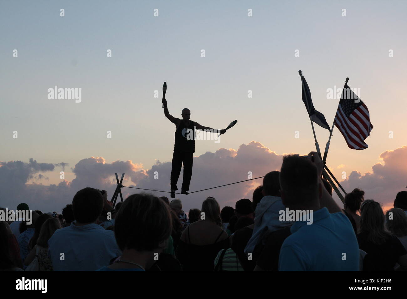 Acrobat walking on a wire at sunset in Mallory Square, Key West ...