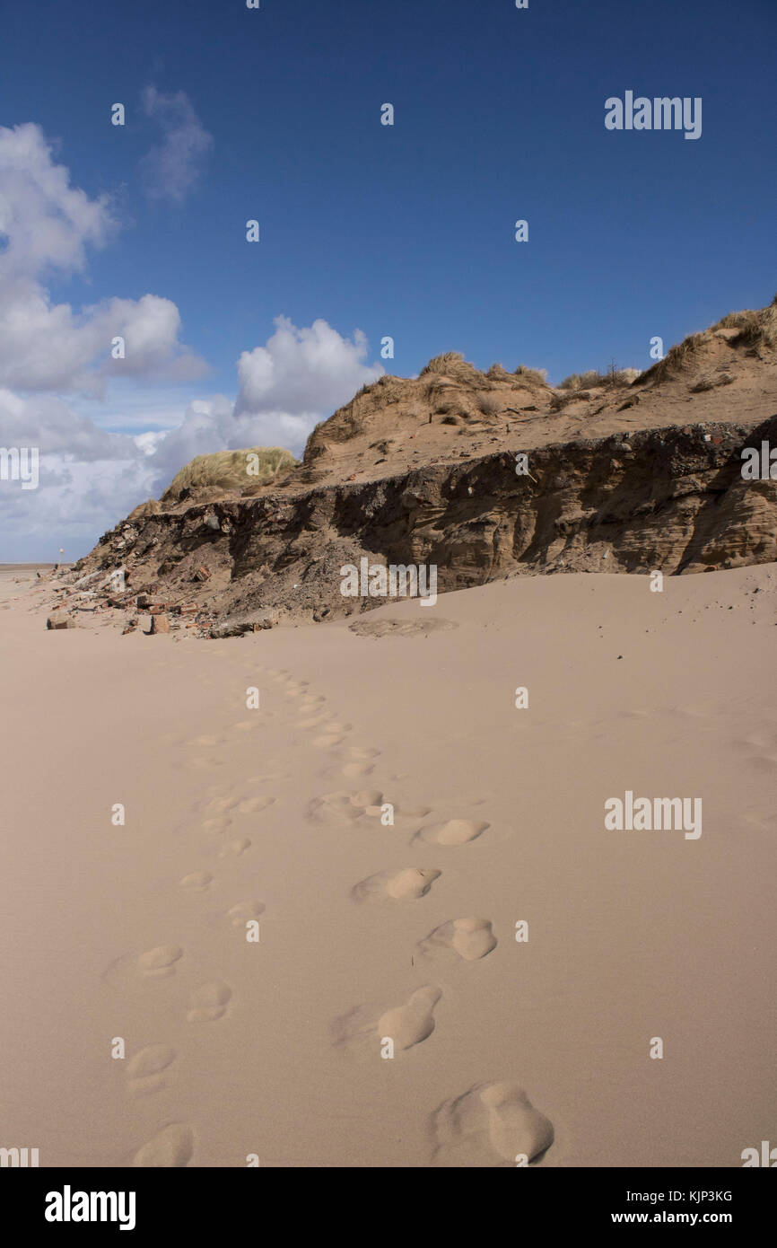 footprint trail leading up to sand dunes showing coastal erosion at ...