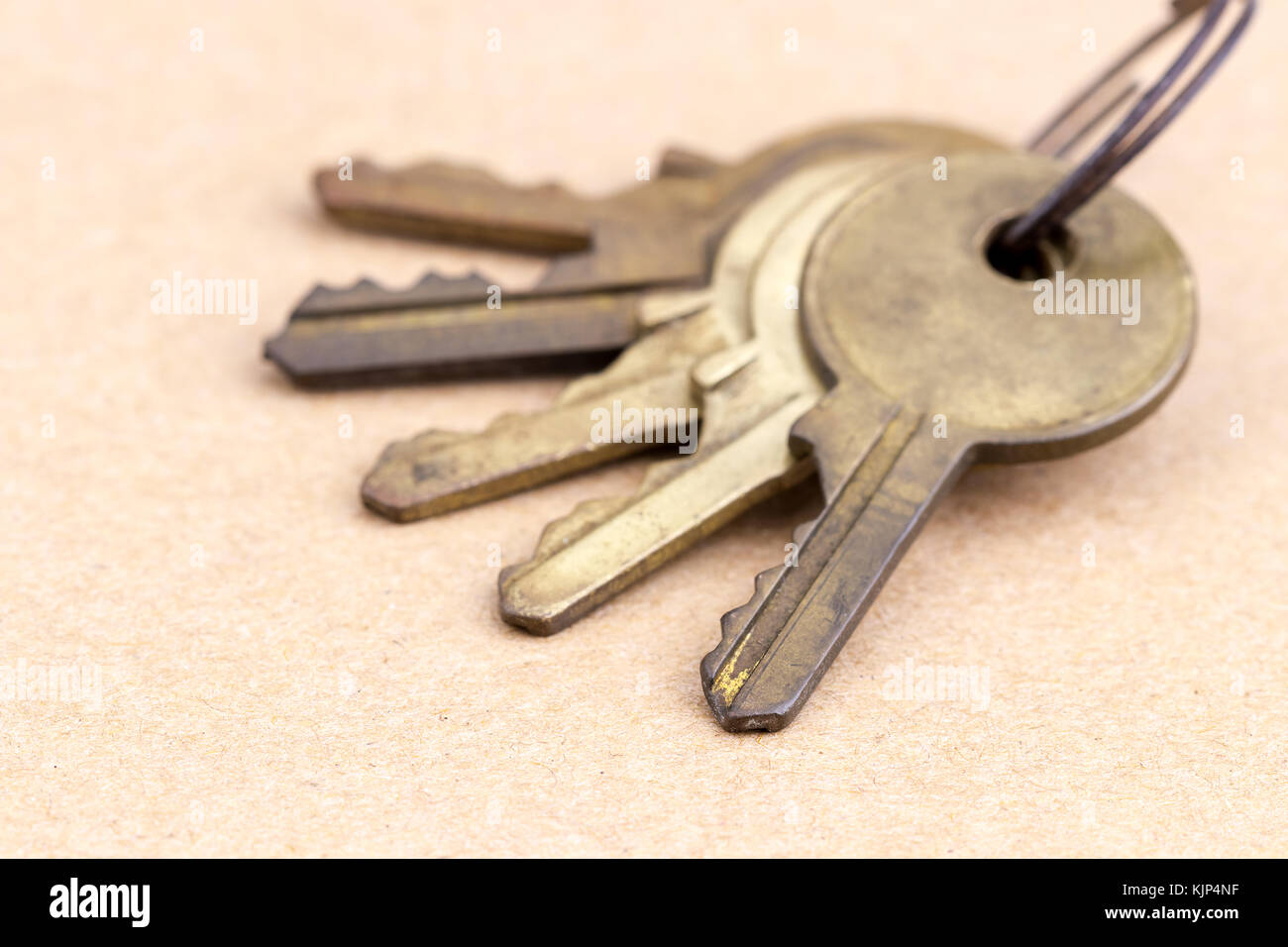 Old brass keys with key chain on brown background Stock Photo - Alamy