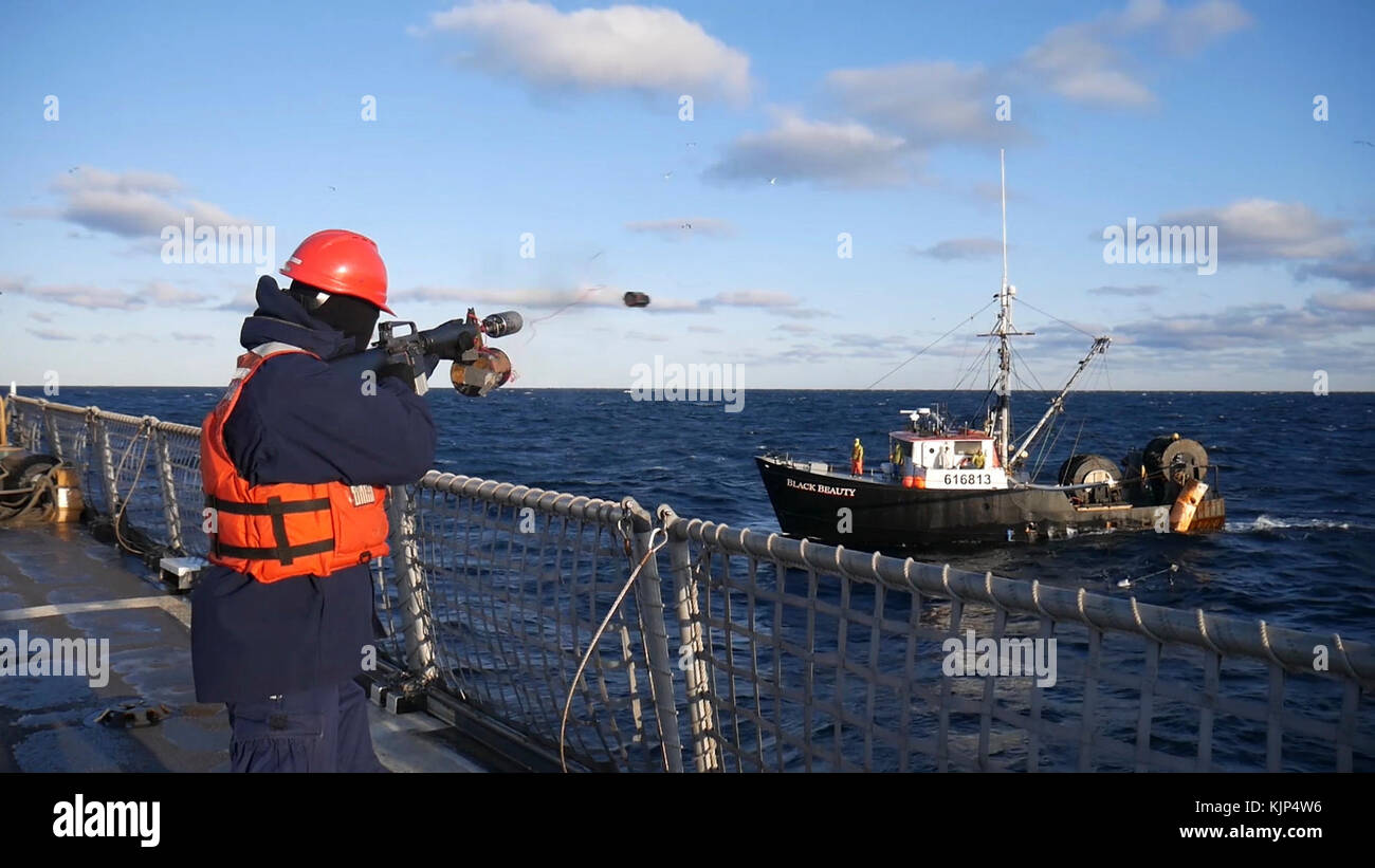 Petty Officer 3rd Class Anderson Ernst uses a line throwing gun to help ...