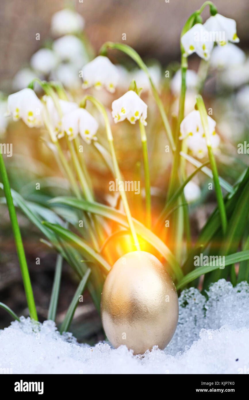 Easter egg and spring snowflakes surrounded by melting snow Stock Photo ...