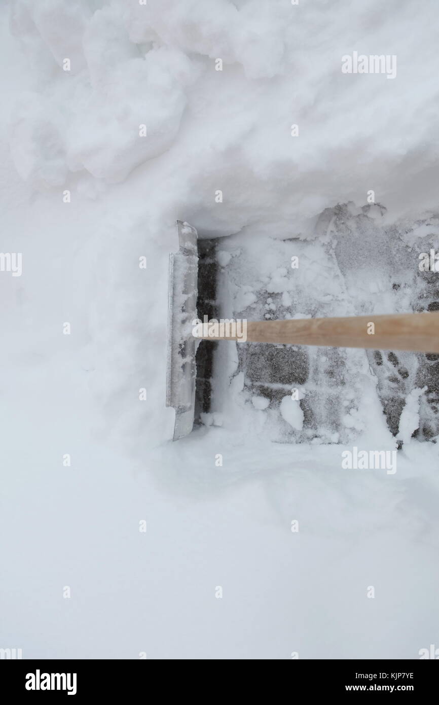 Shoveling snow from driveway: shovel in snow Stock Photo - Alamy