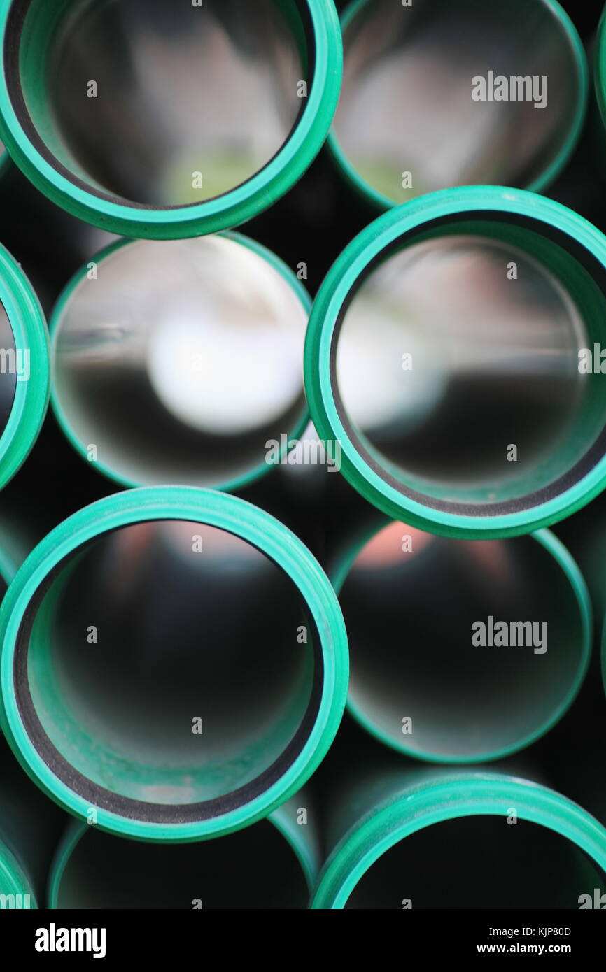 a stack of green pipes in a construction zone Stock Photo - Alamy