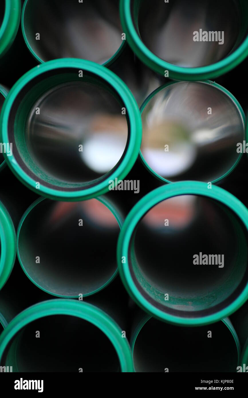 a stack of green pipes in a construction zone Stock Photo - Alamy