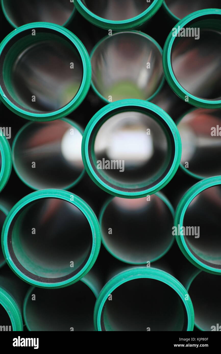 a stack of green pipes in a construction zone Stock Photo - Alamy
