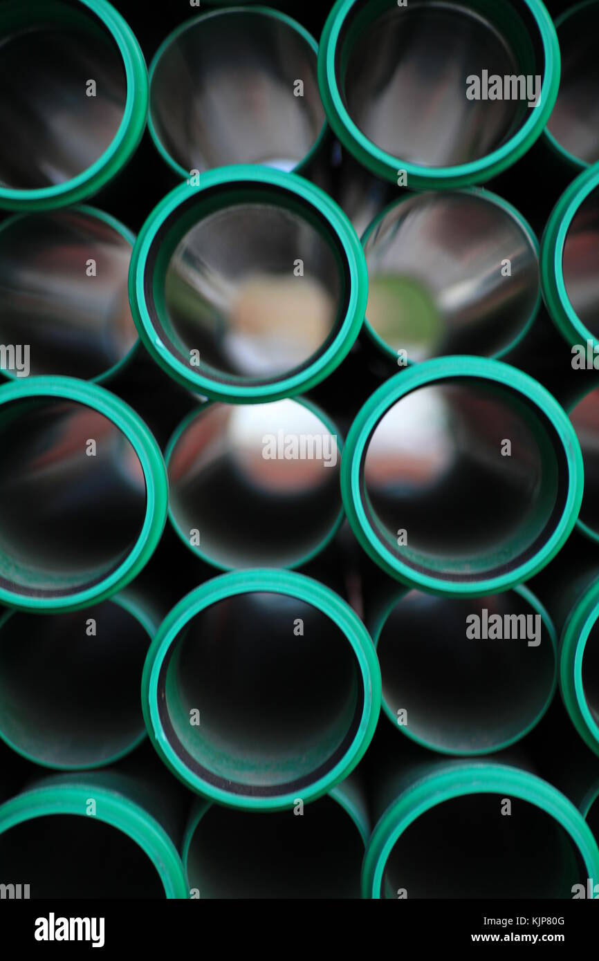 a stack of green pipes in a construction zone Stock Photo - Alamy