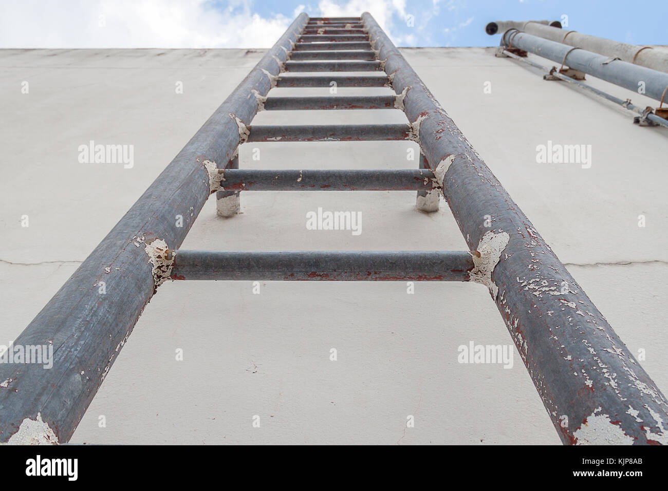 Old vertical industrial metal rusted ladder. Staircase to blue sky with ... Old vertical industrial metal rusted ladder. Staircase to blue sky with ...
