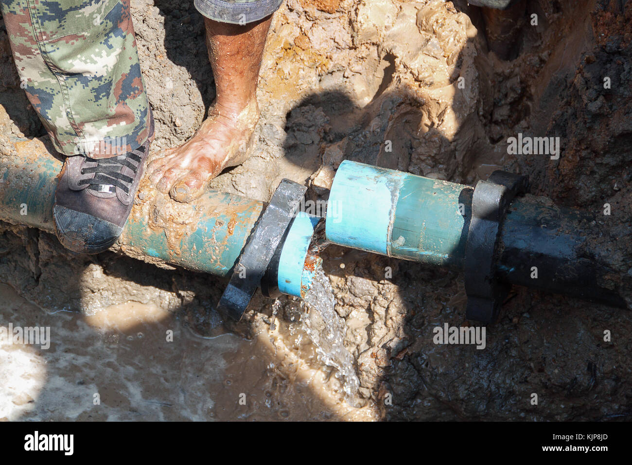plumber workers repair pipe water main broken, tube underground water ...