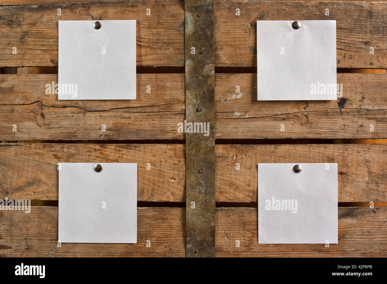 Four pieces of blank paper tacked to wooden background.Ready for your ...