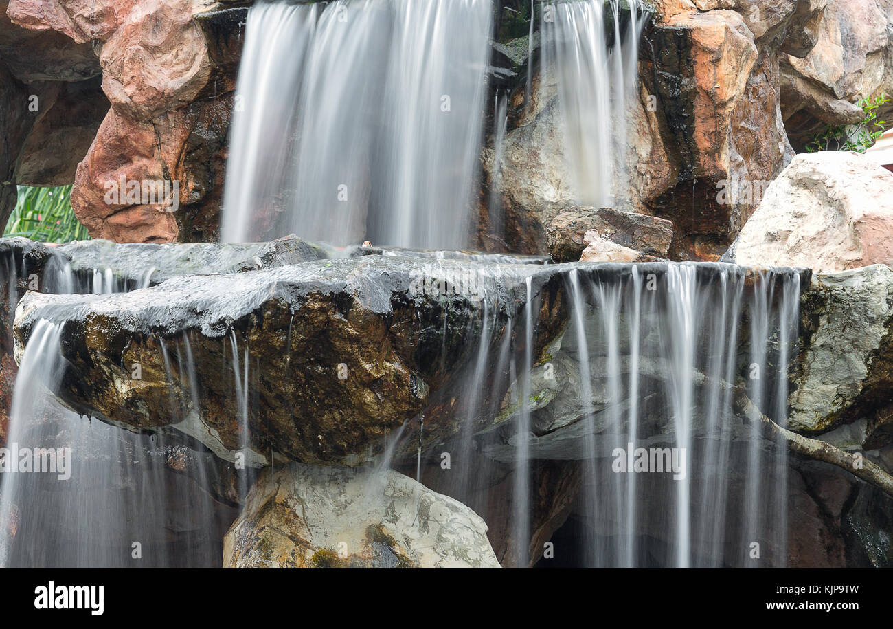 Waterfall flowing over rocks in the garden. Beautiful of waterfalls ...