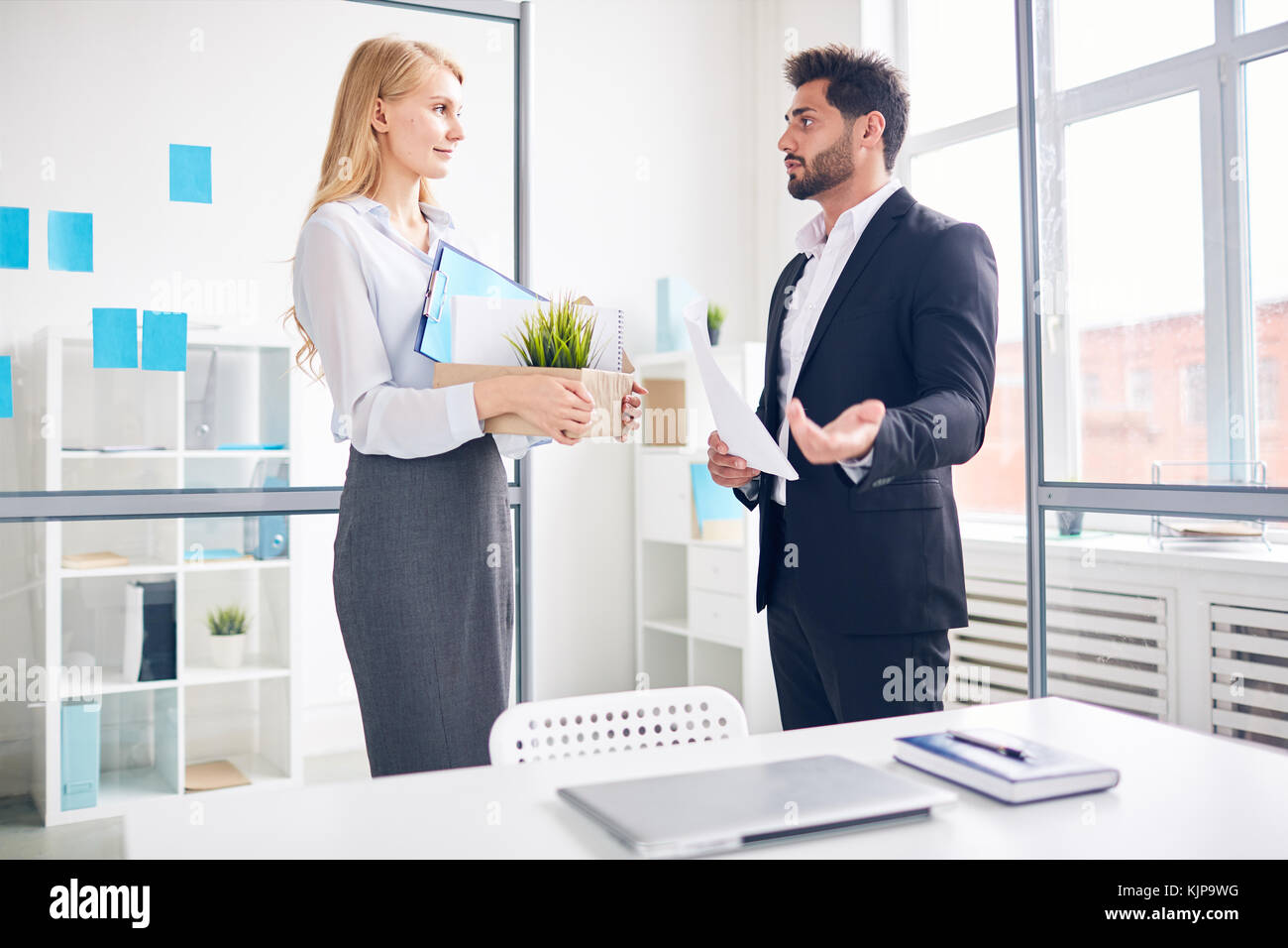 Elegant boss showing new employee her workplace in office Stock Photo ...