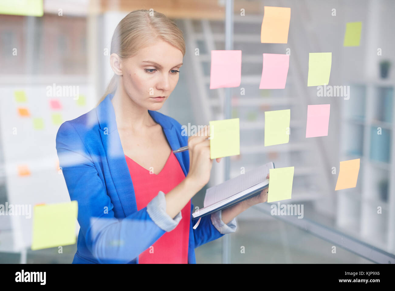 Young manager making notes and pointing out main tasks for the day ...