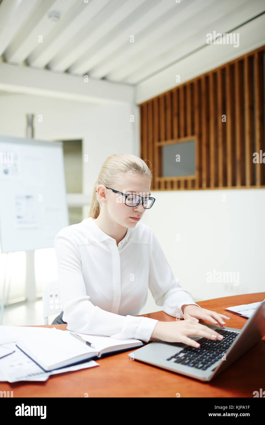 Young manager or secretary staying in office to carry out overtime work ...
