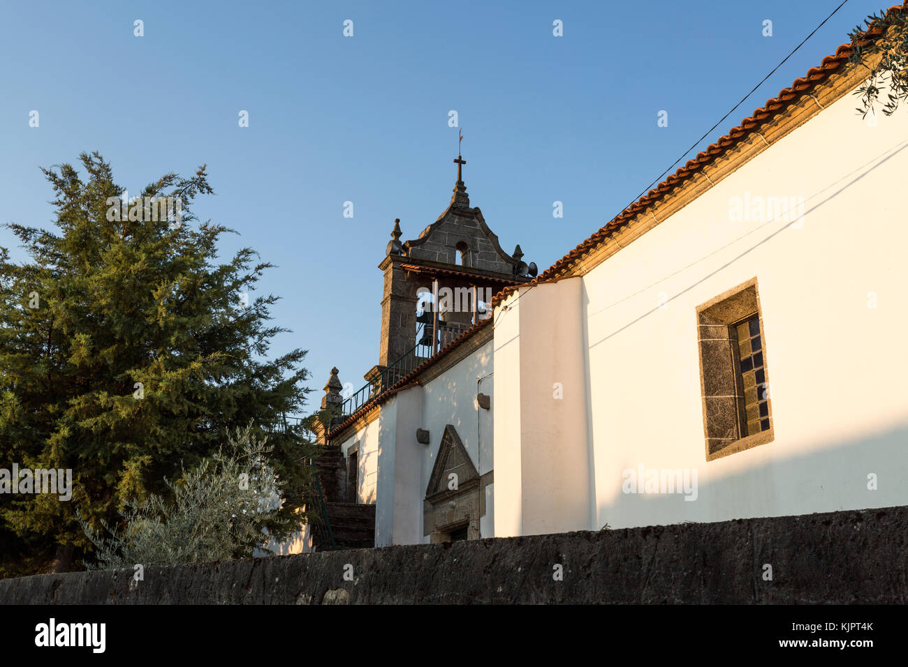 Parish church of Sao Romao with double bells, clock and cross on top of ...