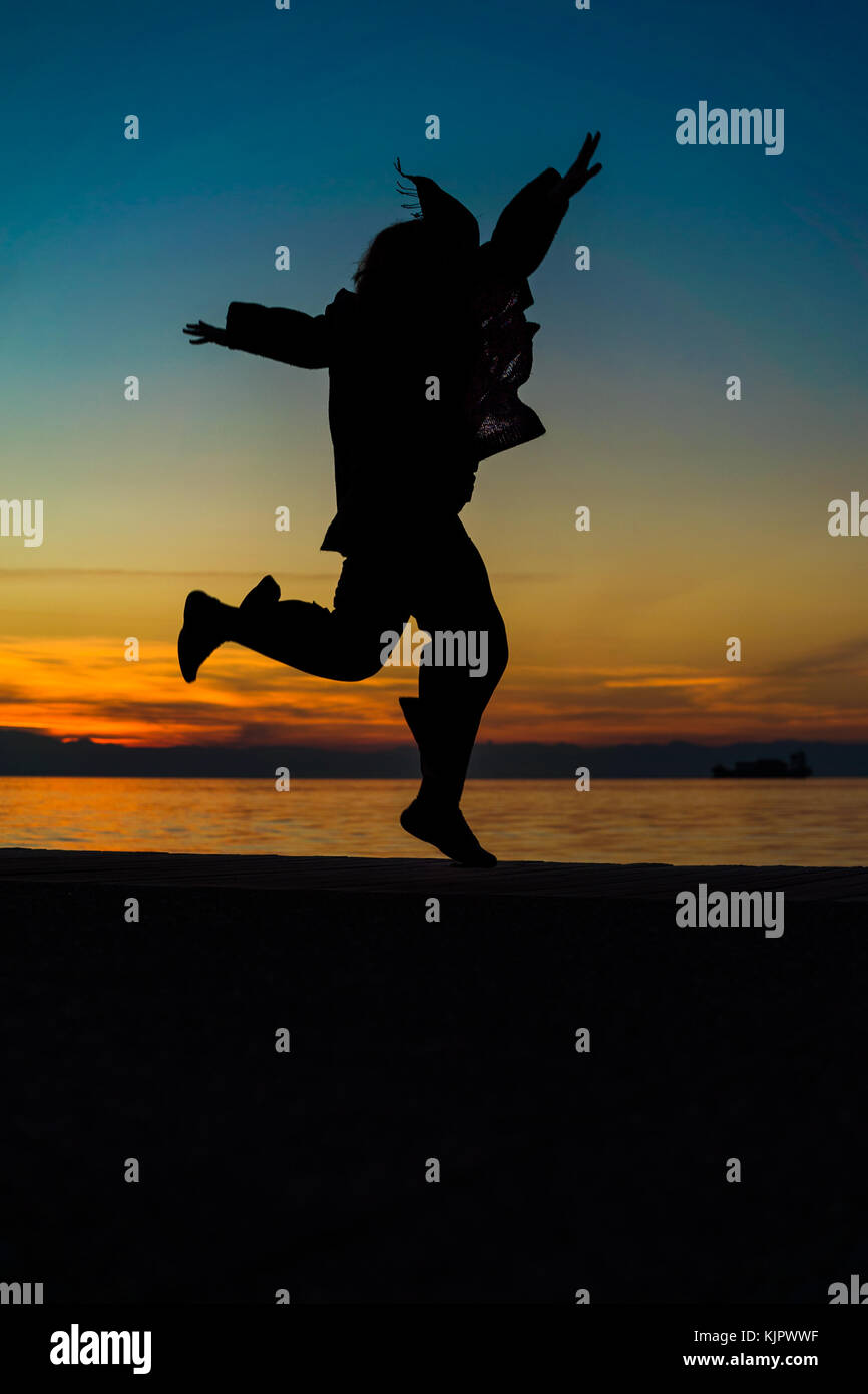 Sihouette of Happy Woman Dancing with Joy , against beautiful after ...