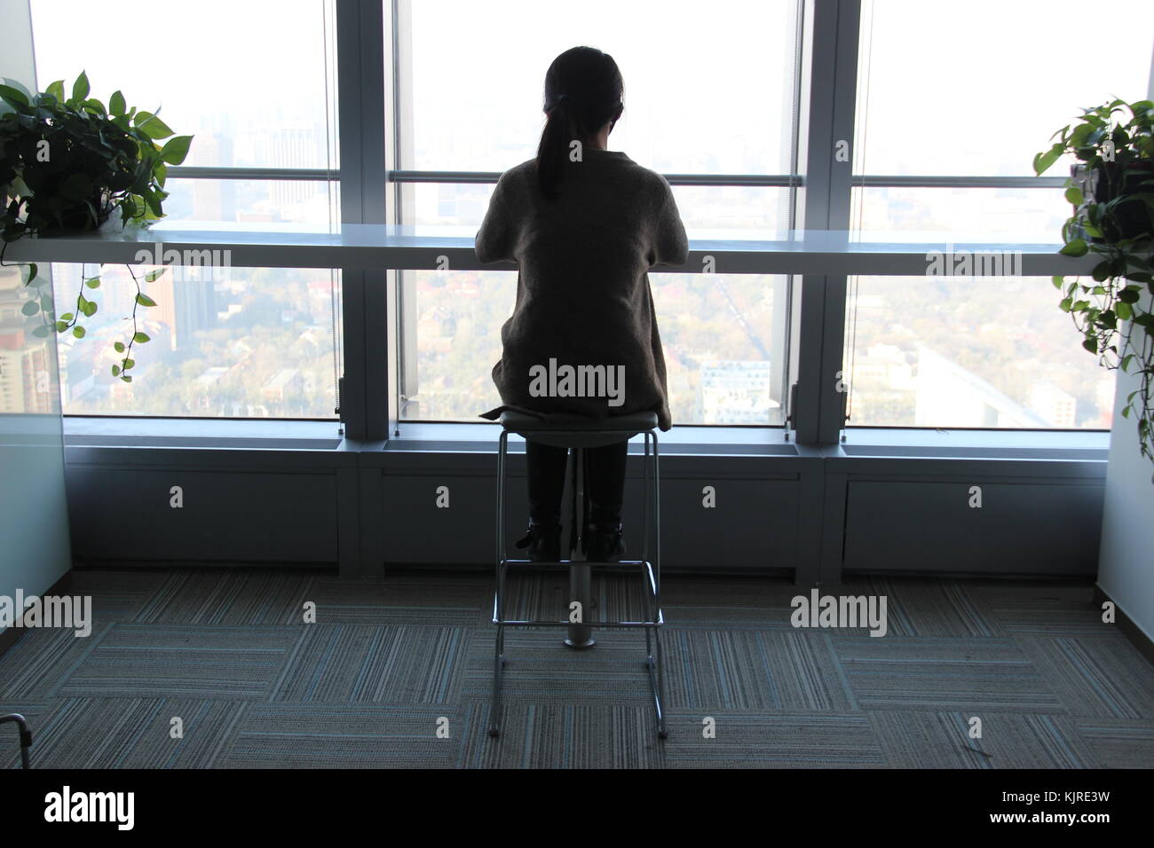 Figure sitting on a counter Stock Photo - Alamy