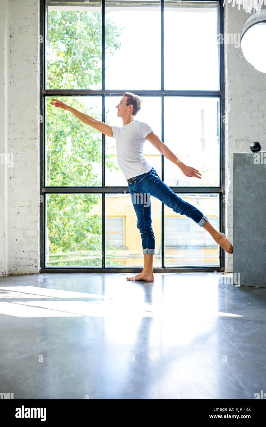 A handsome young male Ballet dancer practicing in a Loft style ...
