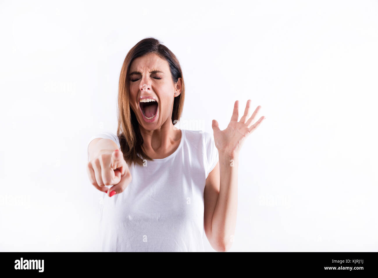 A beautiful young woman pointing to the camera and screaming Stock ...