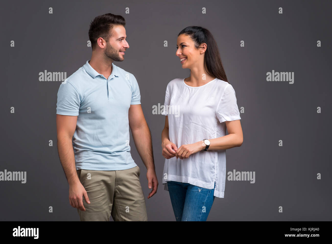A beautiful young couple standing and laughing in good mood Stock Photo ...