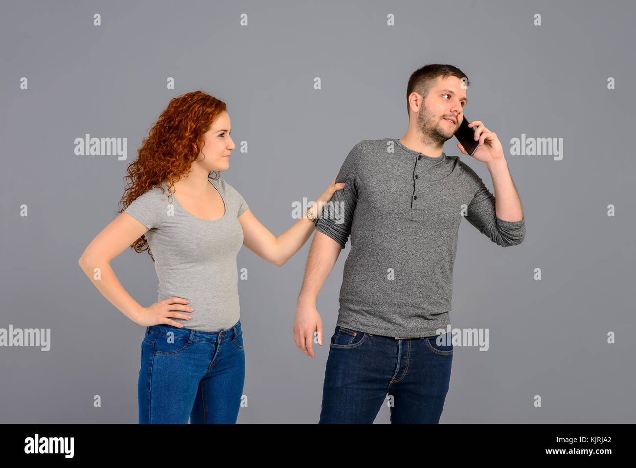 A handsome young guy standing and talking on his phone and ignoring his ...