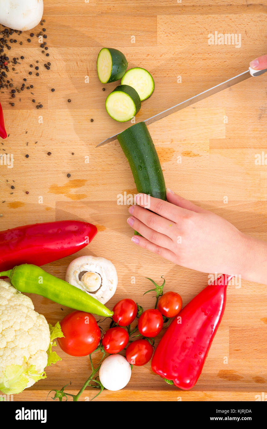 A woman chopping up vegetables at a table Stock Photo - Alamy