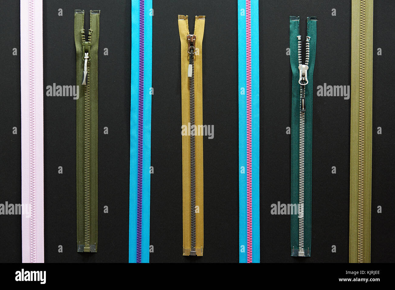 Zippers for clothes on a black background Stock Photo - Alamy