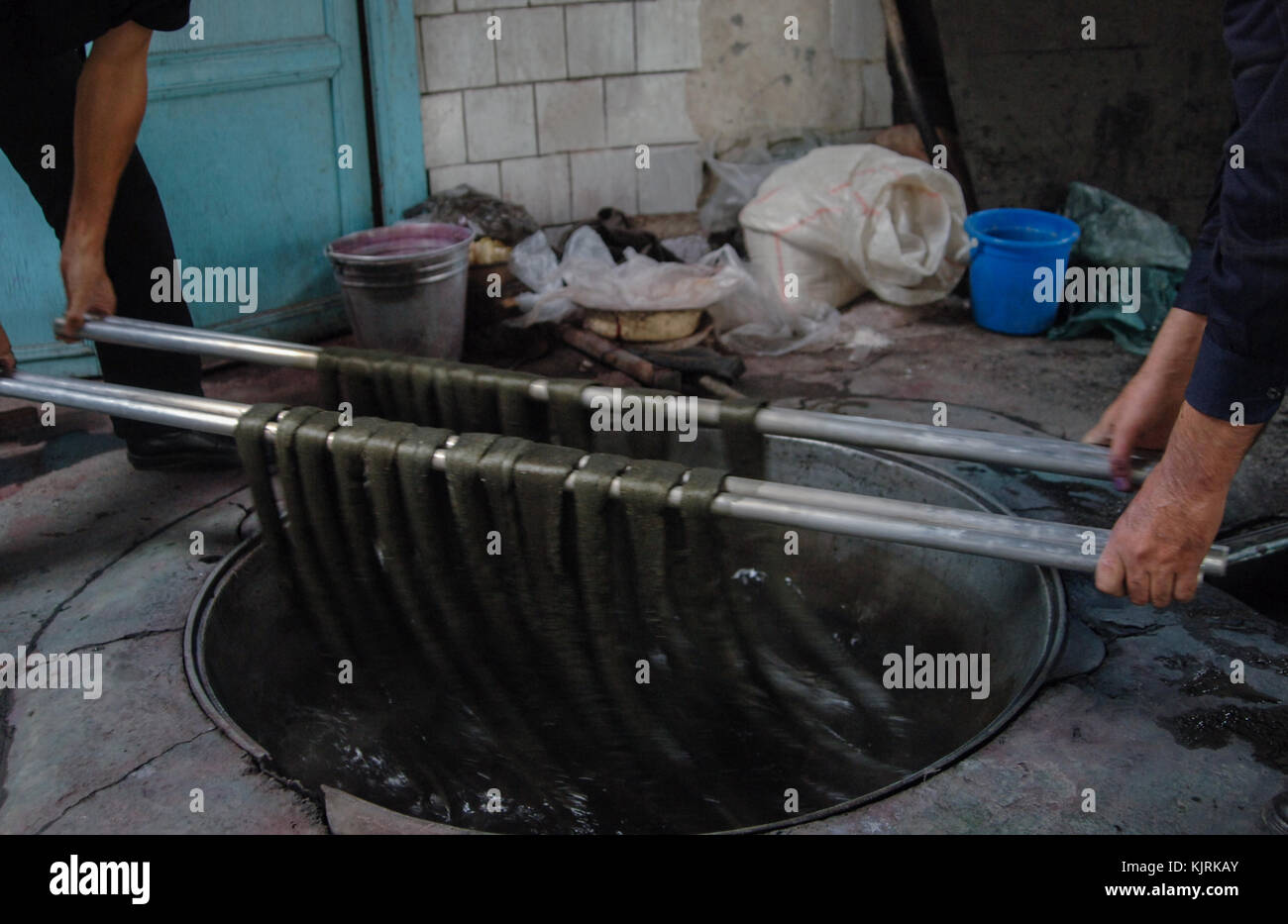 dyeing of finished yarn. two men manually dye yarn Stock Photo - Alamy