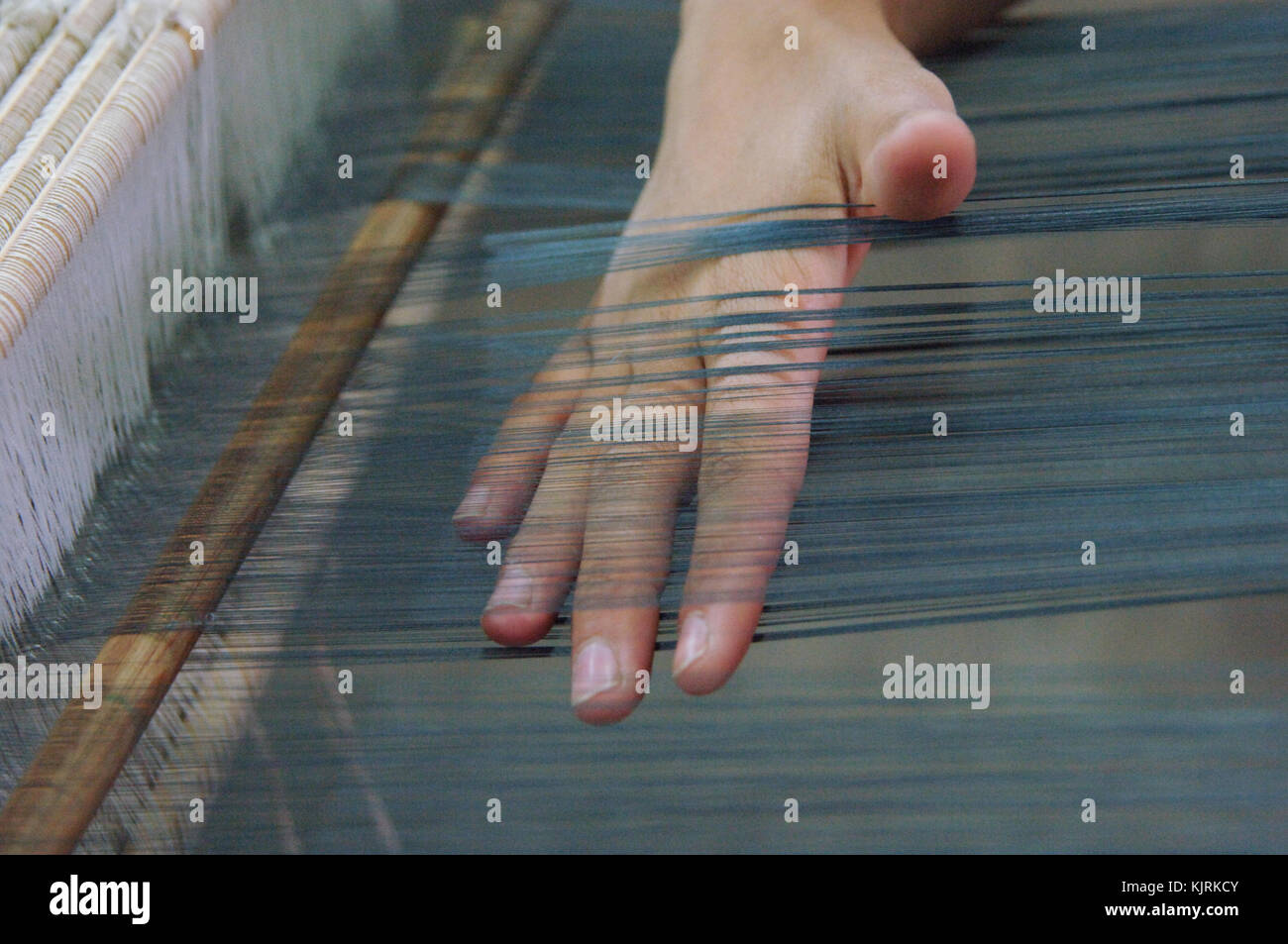 weaving and manufacturing of handmade fabric close up. women's hands ...